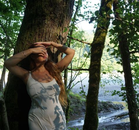 Premium Photo Woman Standing Against Tree Trunk In Forest