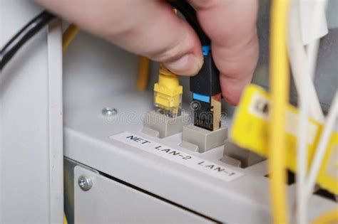 Technician Plugging Ethernet Cable Into Network Switch Close Up Of
