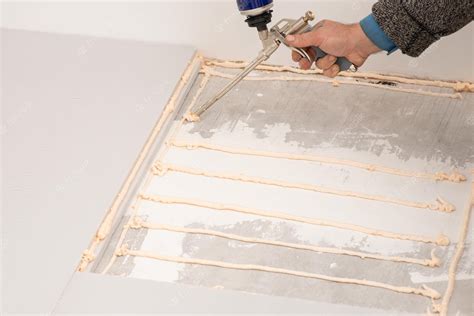 Premium Photo Applying Glue On Concrete Floor For Sticking Sheet Of Styrofoam
