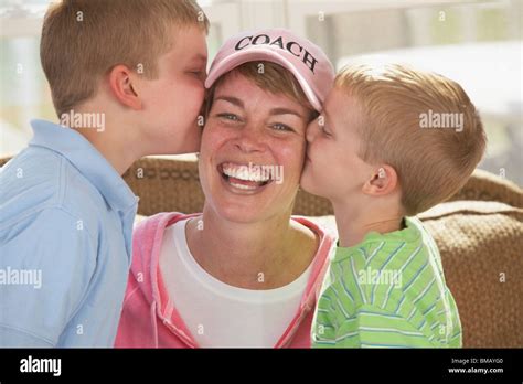 Two Sons Kissing Their Mother S Cheeks Stock Photo Alamy
