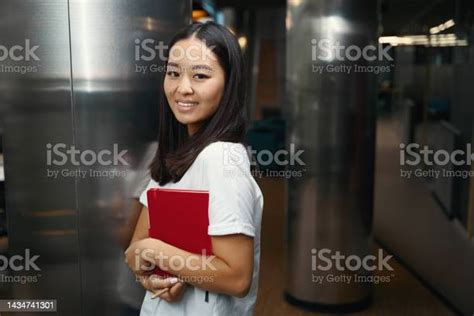 사무실에 있는 유리문 근처에 서 있는 노트북을 손에 들고 웃는 여자 25 29세에 대한 스톡 사진 및 기타 이미지 25 29