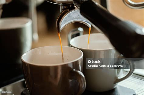 커피 머신에서 쏟아지는 에스프레소의 클로즈업 전문 커피 양조 술집 바 레스토랑에서 커피를 만드는 에스프레소 머신 뜨거운 붓는