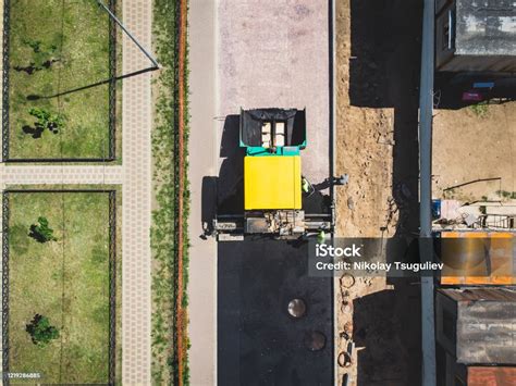도로 건설 및 수리 작업 중 아스팔트 포장 기계 및 증기 도로 롤러 아스팔트 및 포장 과정 새로운 도로 건설 현장에서 일하는 근로자 층 배치 무인 항공기 개발에 대한 스톡