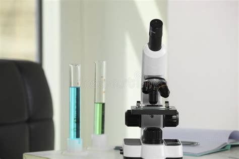 Modern Microscope With Glass Slide On White Table In Laboratory Space