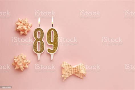 축제 장식이 있는 파스텔 핑크 배경에 숫자 89가 있는 양초 생일 축하 촛불 생일 기념일 중요한 날짜 휴일을 축하하는 개념입니다
