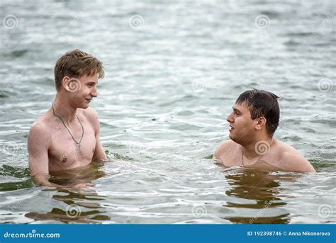 Two Guys Swim In The Lake In The Summer In Cold Weather The Concept Of