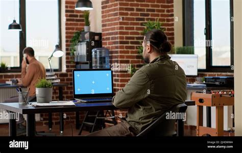 Businessman Looking At Greenscreen On Wireless Laptop In Company Office