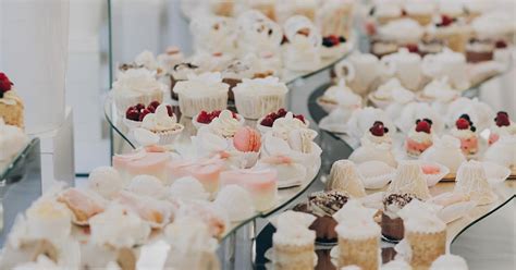 축하 행사에서 현대적인 달콤한 테이블 맛있는 케이크 쿠키 핑크와 화이트 색상의 과일이 있는 컵케이크가 있는 세련된 캔디 바