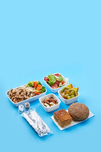 푸른 배경 일회용 플라스틱과 호일 식기류 비행기 식품 간식 둥근 쌀 닭고기와 찐 야채 과일 접시 건강한 쿠키 일회용 칼 베이글과 케이크 0명에 대한 스톡 사진 및 기타