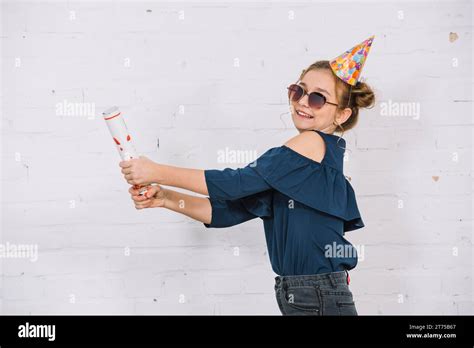 Smiling Teenage Girl Letting Off Party Popper Standing Front White Wall