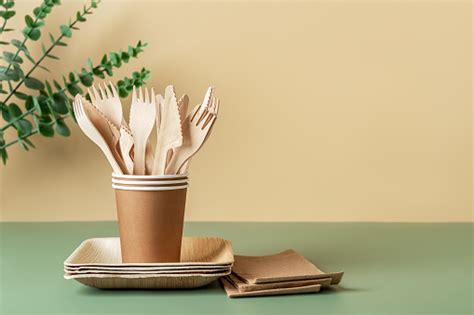 베이지 색 녹색 배경에 대한 일회용 요리와기구 접시에 갈색 종이 컵에 생분해 성 나무 칼 붙이 환경 친화적 인 식기 및 재활용 개념 공간을 복사합니다 그릇에 대한 스톡 사진