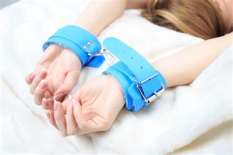 Mans Hand Holding A Womans Hands The Girl In Red Leather Handcuffs Sex Toys Stock Photo
