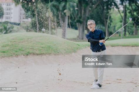 그의 아이언 클럽과 모래 트랩에 자신의 골프 공을 치는 아시아 중국 노인 골퍼 골프에 대한 스톡 사진 및 기타 이미지 골프