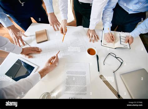 Group Of Architects Discussing Sketch Of Construction By Desk Stock Photo Alamy
