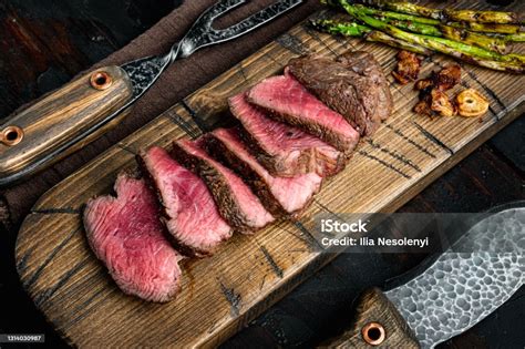 구운 필렛 쇠고기 스테이크 양파와 아스파라거스 나무 제공 보드에 고기 칼과 포크 오래된 어두운 나무 테이블 배경 0명에 대한 스톡 사진 및 기타 이미지 Istock