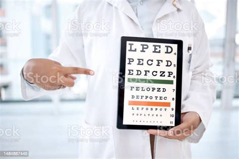 병원에서 시력 검사를 위해 병원에 있는 손 태블릿 화면 및 시력 차트 의료 Snellen 또는 여성 안과 의사 또는 의사는 시력 검사를 위한 문자를 보여주는 기술을
