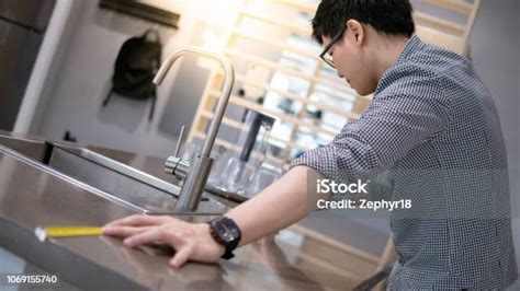 젊은 아시아 남자 쇼 룸에서 현대 부엌 카운터에 화강암 싱크대를 측정 하기 위한 측정 테이프를 사용 하 여 홈 개선 위한 가구 쇼핑 인테리어 디자인 컨셉 가구에 대한 스톡