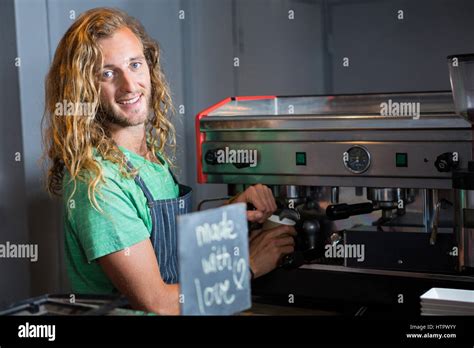 Portrait Of Barista Preparing Coffee In Coffee Machine At Coffee Shop