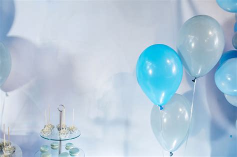 파란색과 투명한 풍선 디저트 마카롱 연한 파란색 천에 유리 쟁반에 케이크가 있는 축제 배경 아기 소년 또는 성별 파티를 위한