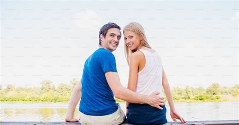 부두에 함께 앉아 미소로 어깨 너머로 바라보는 아름다운 젊은 사랑하는 커플 사진 Unsplash의 앉아 이미지