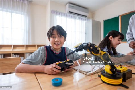 초등학교 교실에서 공부하는 아시아 학생들의 초상화 사랑스러운 어린 학생들이 과학 수업을 공부하고 대학에서 재미있는 활동으로 화학 실험을 하면서 카메라를 바라보고 있습니다