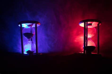 시간 개념입니다 모래 시계 시계와 뜨거운 노란색 주황색 빨간색 파란색 감기로 다시 조명 어두운 배경에 연기의 실루엣 0명에 대한