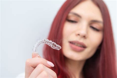 A Woman With A Beautiful Smile Holds Aligners In Her Hand Stock Image