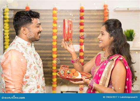 Indian Woman In Traditional Dress Seeing Her Husband Or Partner Through Sieve During Hindu