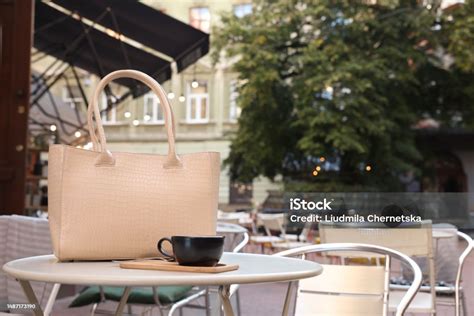 야외 카페의 하얀 테이블에 놓인 세련된 가방과 커피 한 잔 텍스트를 위한 공간 탁자에 대한 스톡 사진 및 기타 이미지 탁자 가방 가죽 Istock