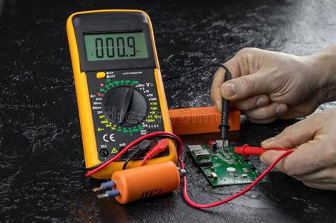 An Electrician Takes Readings From A Microcircuit Using A Multimeter Measuring Instruments
