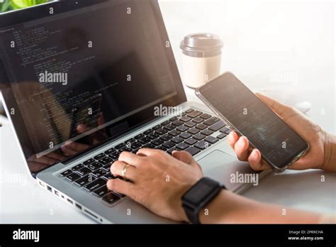 Programmer Woman Looking Mobile Phone Program Code At Workplace