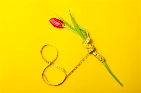 명함 빨간색 튤립과 센티미터 테이프는 복사 공간이 있는 노란색 배경에 숫자 8 모양입니다 피트니스 인사말 카드 국제 여성의 날 또는 어머니의 날 바느질 취미 꽃집 0명에