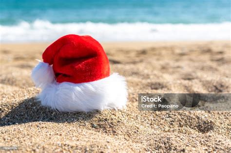 모래 해변에 산타 클로스 모자입니다 창조적 인 크리스마스 또는 새해 개념 크리스마스에 대한 스톡 사진 및 기타 이미지 크리스마스 해변 12월 Istock