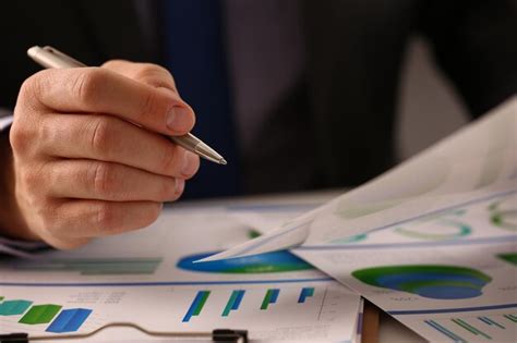 Premium Photo Businessman Pen Pointing At Business Document For Chart And Graph Data Analysis