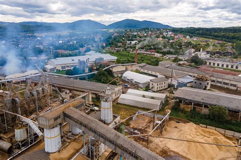 공장 제조 야드의 환경을 오염시키는 생산 공정의 연기 더미가있는 목재 가공 공장의 조감도 공장 산업 건물에 대한 스톡 사진 및
