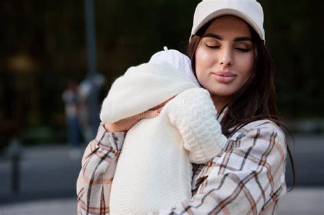 A Beautiful Girl Is Holding A Baby In Her Arms Mother Holding Baby In