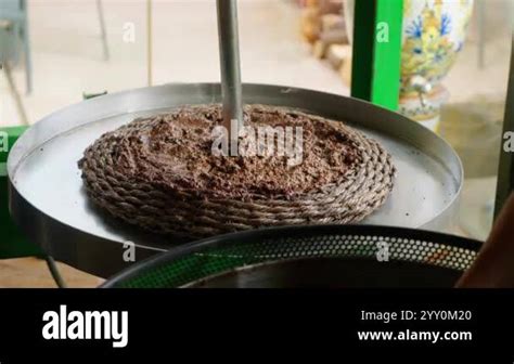 Specialist Adds Olive Pulp To Wicker Plate For Pressing On Farm