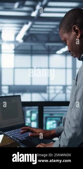 vertical video engineer in data center operating notebook deploying