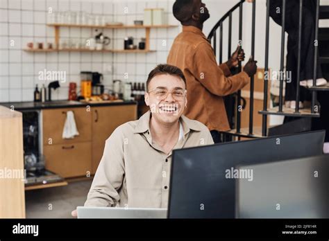 portrait of happy male computer programmer sitting in office stock