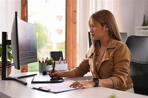 컬러 팔레트로 작업하고 그래픽 스튜디오에서 디자인 프로젝트를위한 색상 샘플을 선택하는 데 중점을 둔 젊은 창조적 인 여성