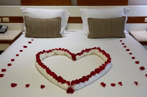 A Heart Of Rose Petals And Towels On A Hotel Bed Stock Image Image