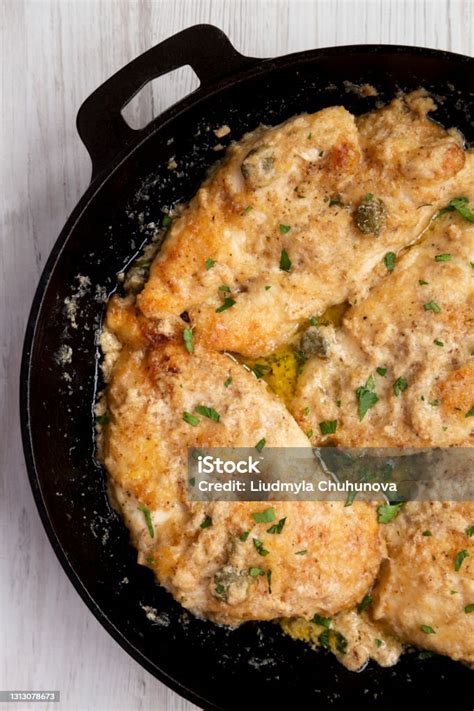 흰색 나무 테이블에 주철 팬에 수제 이탈리아 치킨 Piccata 상단 보기 오버 헤드 위에서 평평한 평지 가금류에 대한 스톡 사진 및 기타 이미지 Istock