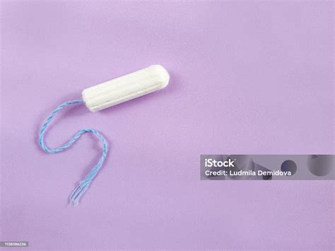 보라색 배경에 면 탐폰 1 개 생리 주기 기간 개념입니다 여성 일 위생 보호 평면도 평 신도 체내형 생리대에 대한 스톡 사진 및