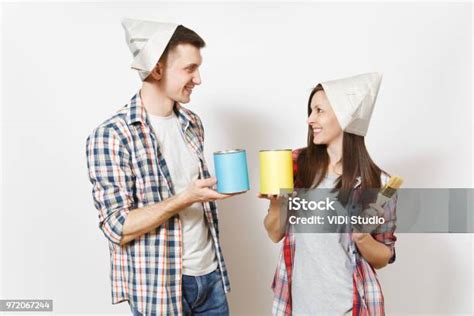 젊은 행복 한 여자 남자 캐주얼 옷 들고 페인트 브러시 복사 공간을 가진 빈 페인트 주석 수 있습니다 흰색 배경에 고립 된 커플입니다 재건축 아파트 룸 악기입니다 수리 가정