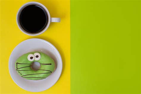 건강에 해로운 다이어트와 간식의 개념입니다 노란 배경에 고립 된 강한 검은 커피 한잔과 함께 달콤한 유약 도넛 녹색 배경에 텍스트 배치 평면도 개념에 대한 스톡 사진 및