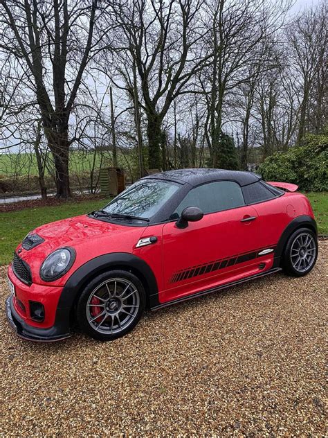 Red Mini Cooper Sports Car In Gravel Parking Lot