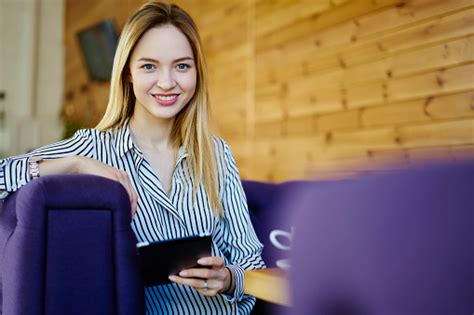 쾌활 한 매력적인 여성 관리자의 웹사이트에 예약에 대 한 Wifi 연결을 사용 하 여 카페 인테리어에 앉아 단정한 블로거 현대