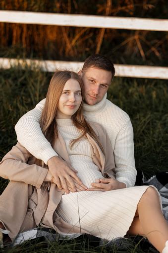 어머니의 날 아기를 기다리는 세련된 결혼 부부 남자는 풀밭에 격자 무늬로 야외에서 여자의 배를 껴안고 만진다 가족의 날 임신 부모 모성 사랑 가족 개념 20 24세에 대한