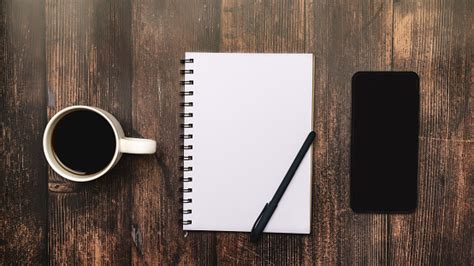 백지 공책 커피 한 잔이 있는 작업 테이블 배경의 맨 위 보기 플랫 누워 다채로운 종이 바인더 클립 메모장과 펜 데스크탑 모형