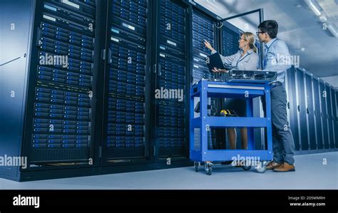 In The Modern Data Center Engineer And It Specialist Work With Server Racks On A Pushcart